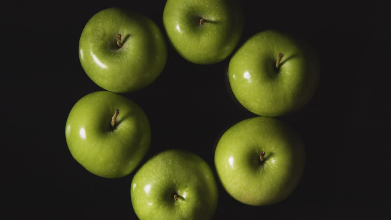 Overhead Studio Shot Of Circle Of Green Apples Revolving Against Black ...