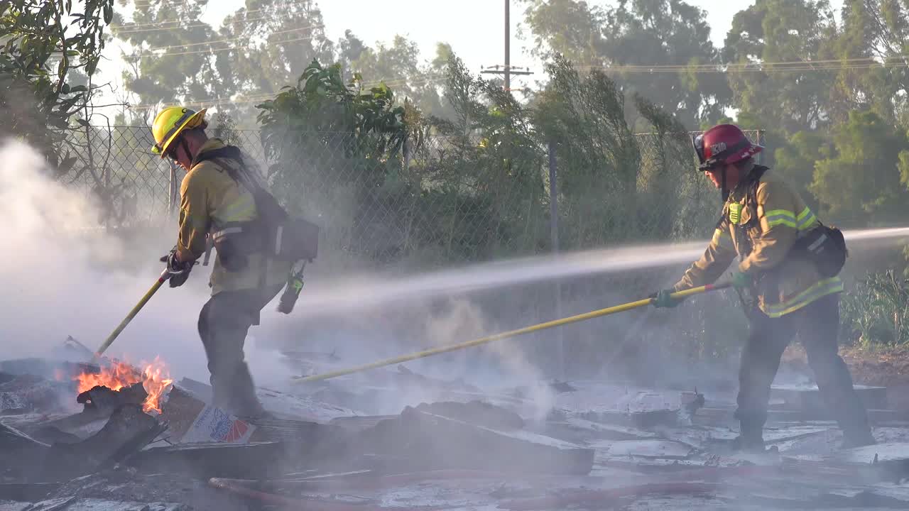 Ground Fire Burns As Firefighters Battle A Burning Structure During The ...