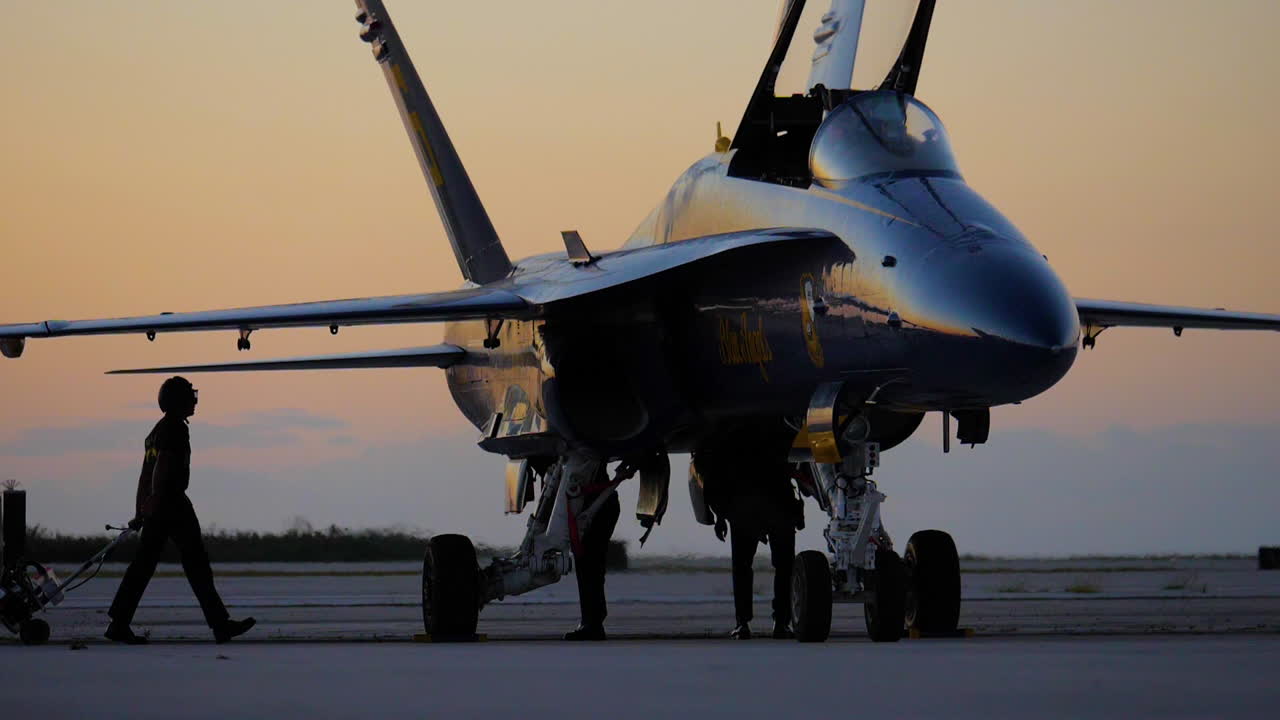 Maintenance Team Member Walks In Front Of Silhouetted Blue Angels Prep ...