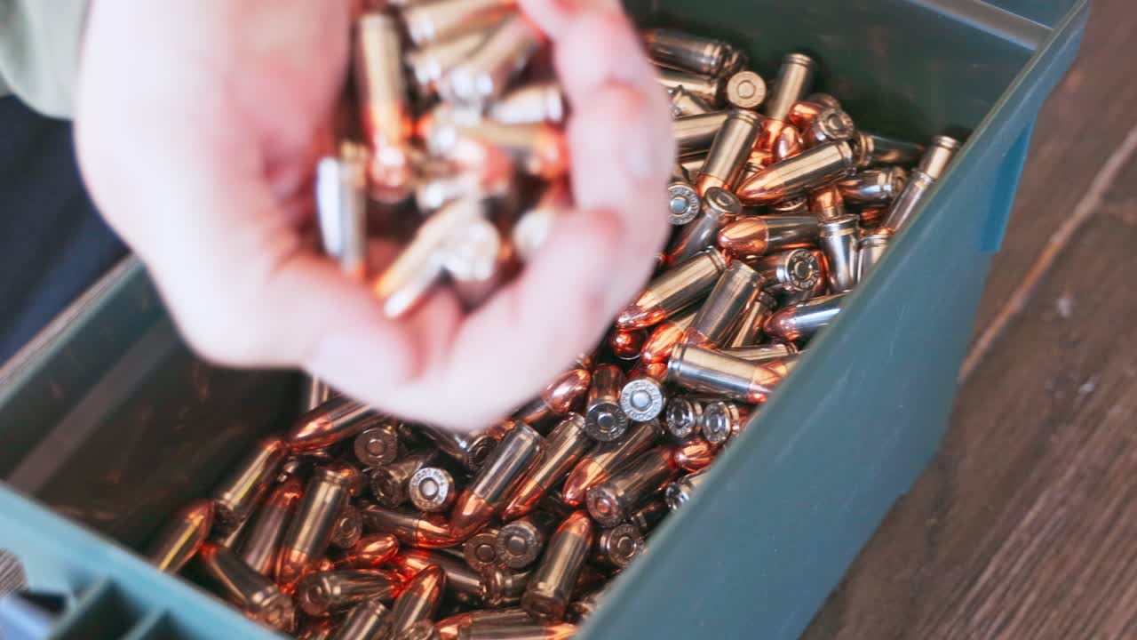 Close Up View Of Someone Opening Up A Can Of 9mm Ammunition, Pulling ...