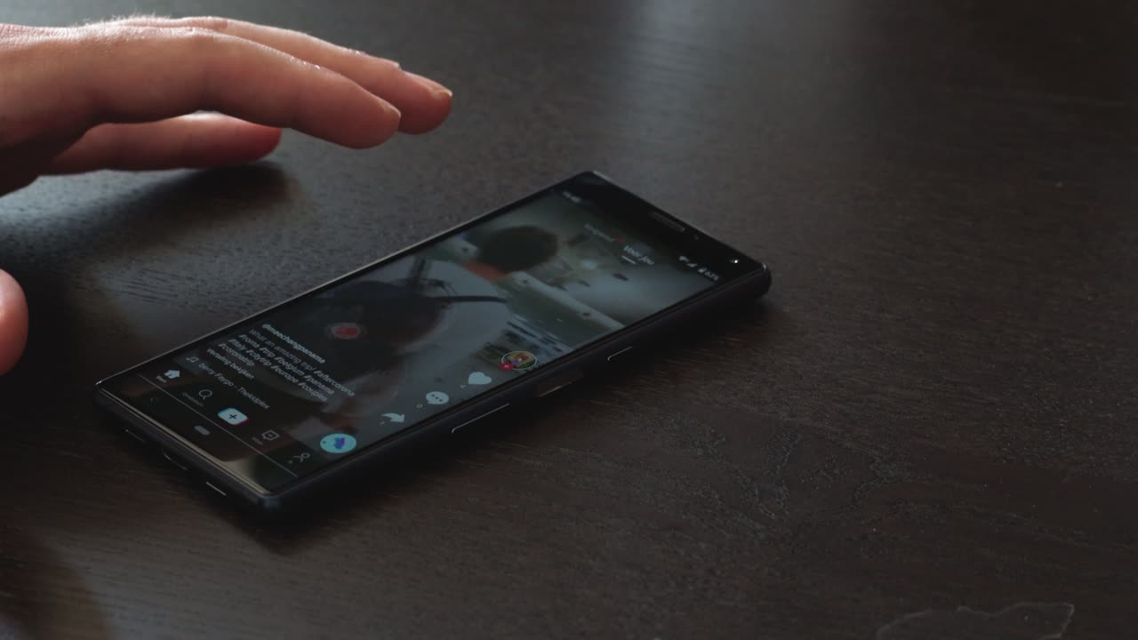 Male Hand Holding And Scrolling Mobile Phone With TikTok Application On The Screen Free Stock ...