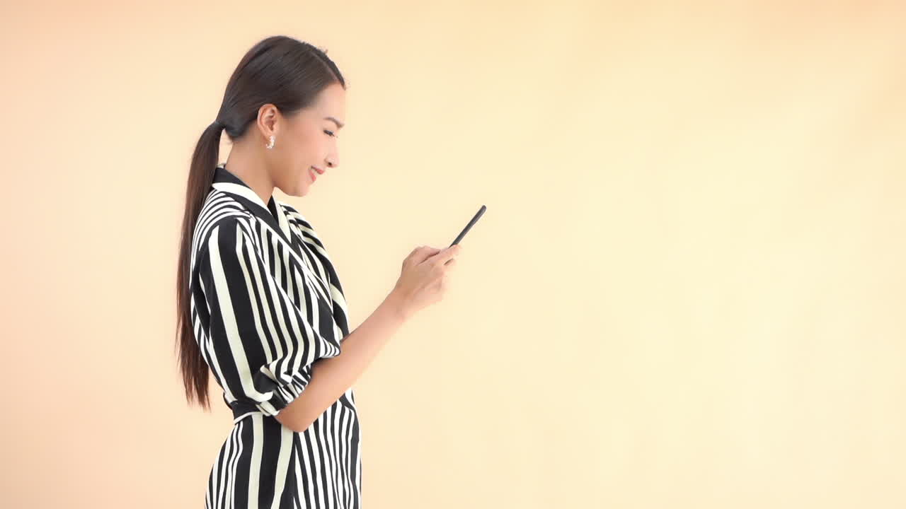 Premium stock video - Young asian woman with long hair texting on smart ...