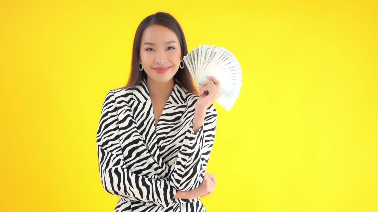 Premium stock video - Crazy rich asian woman posing with money
