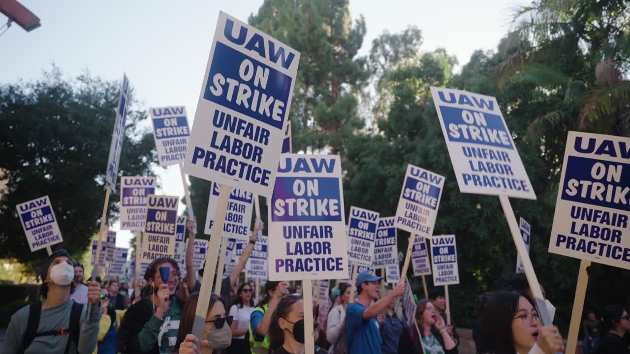 Picket Signs Raised High Above A Crowd Of UC Academic Workers On UCLA's ...