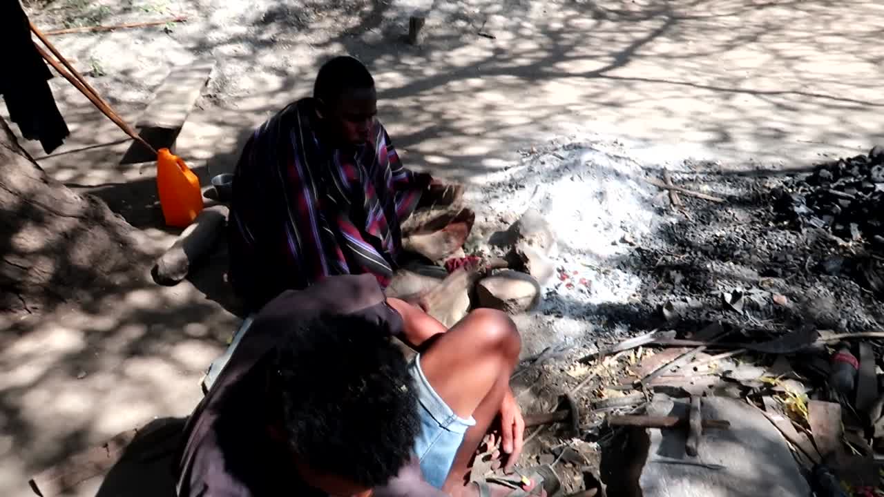 Datoga Tribe Man Creating An Arrowhead While Other Mealt Metal In ...