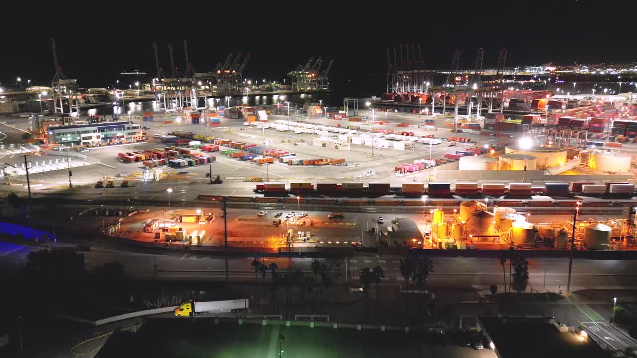 Drone View Of Long Beach Shipyard At Night Showcasing Towering Cranes ...