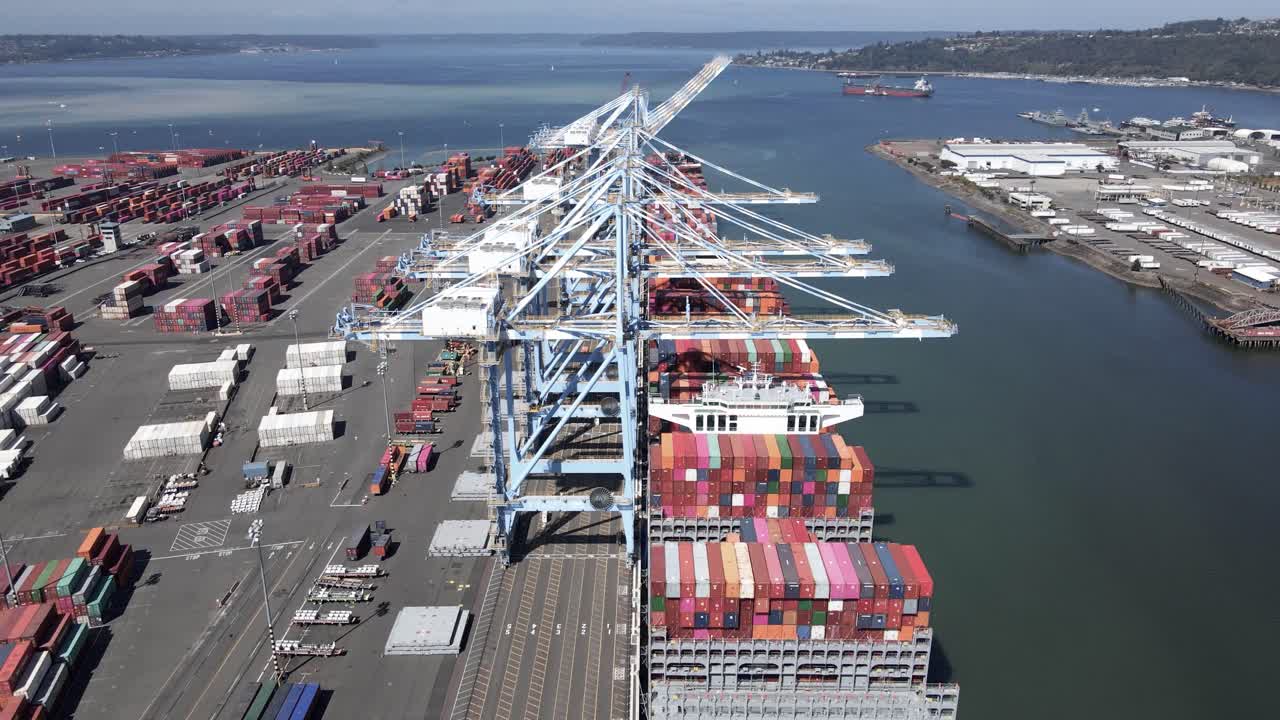 Giant Cranes Unload Multicolored Containers From The Decks Of Container ...
