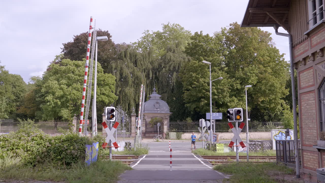 Jogger Walks Trough Railroad Crossing With Barrier And Red Traffic ...