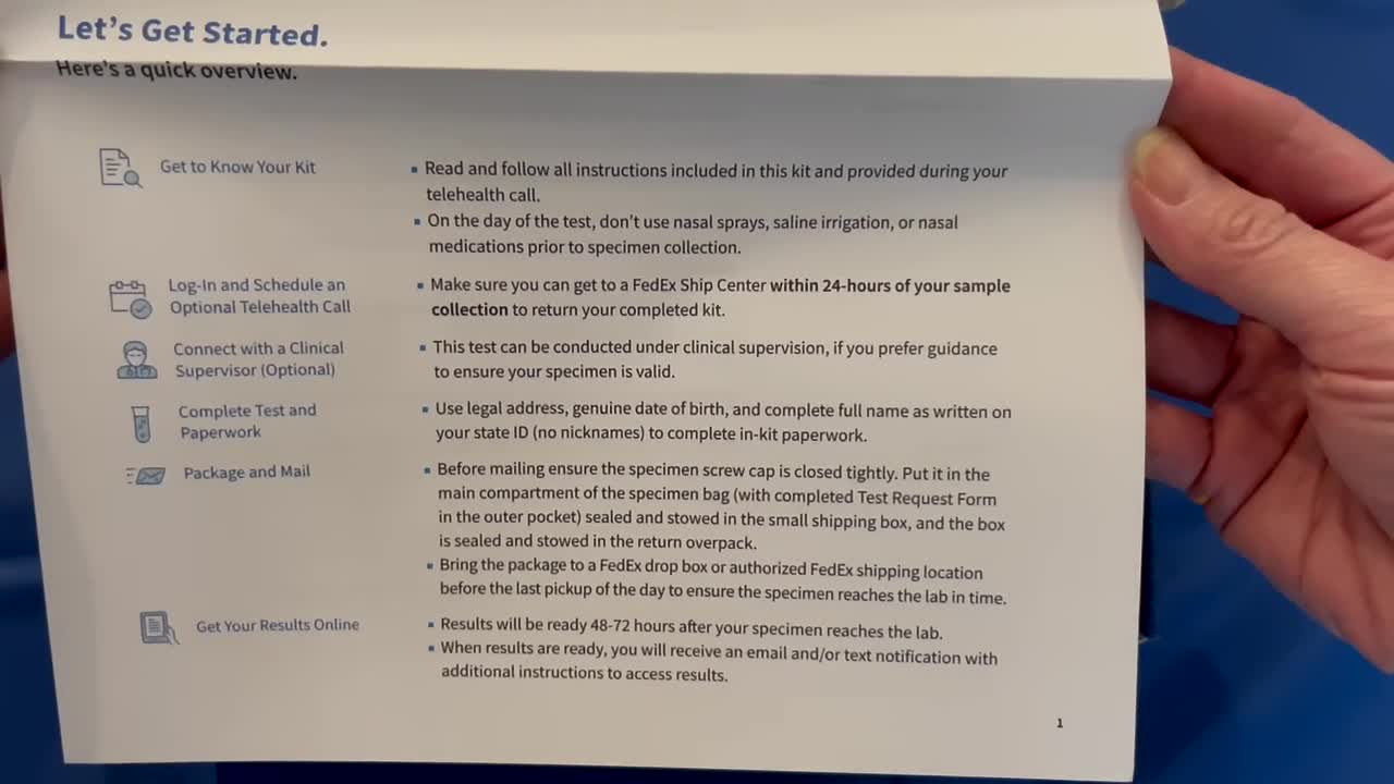 Hand Holding An Instructional Pamphlet For A COVID19 IN HOME NASAL SWAB ...