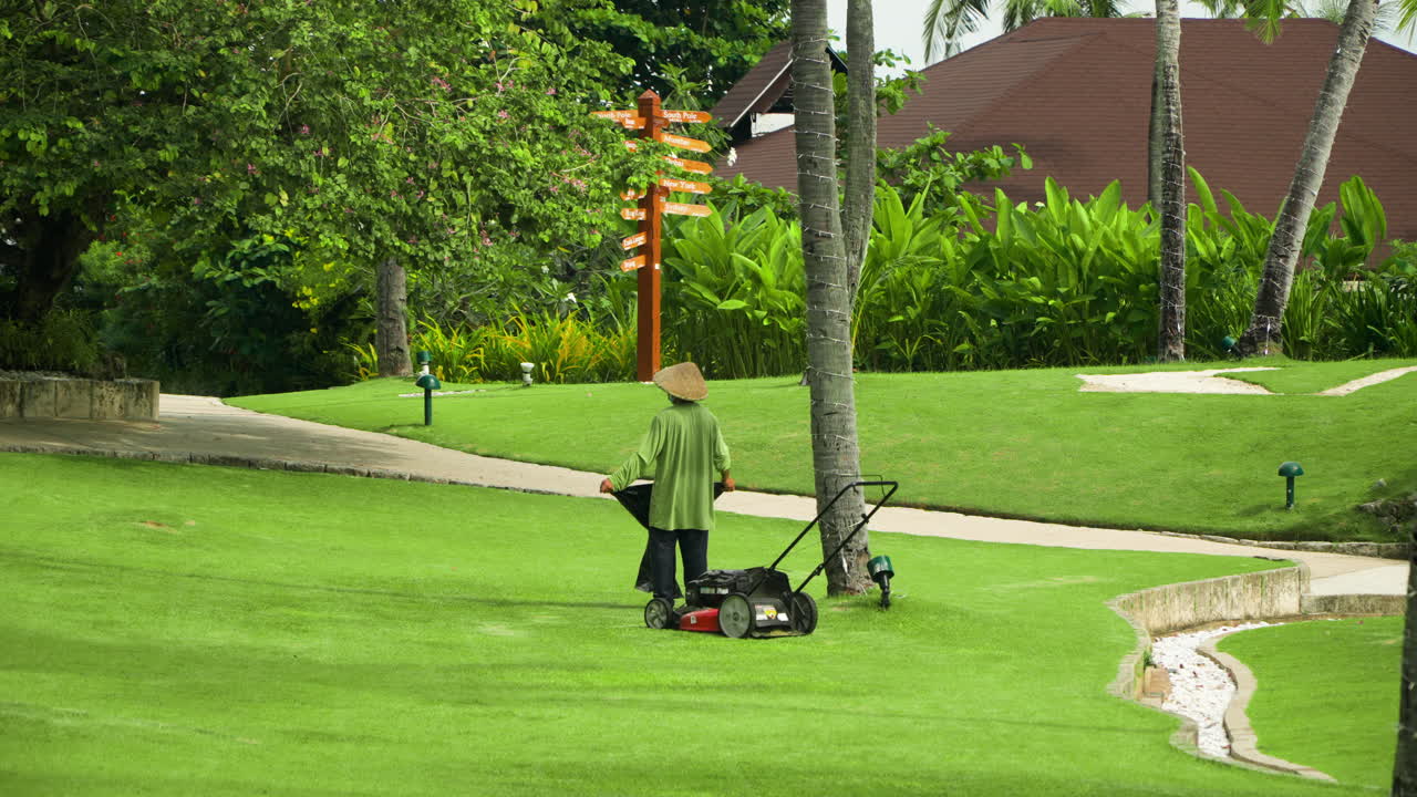 Back View Of A Filipino Worker Standing On Lawn With Push Mower Free ...