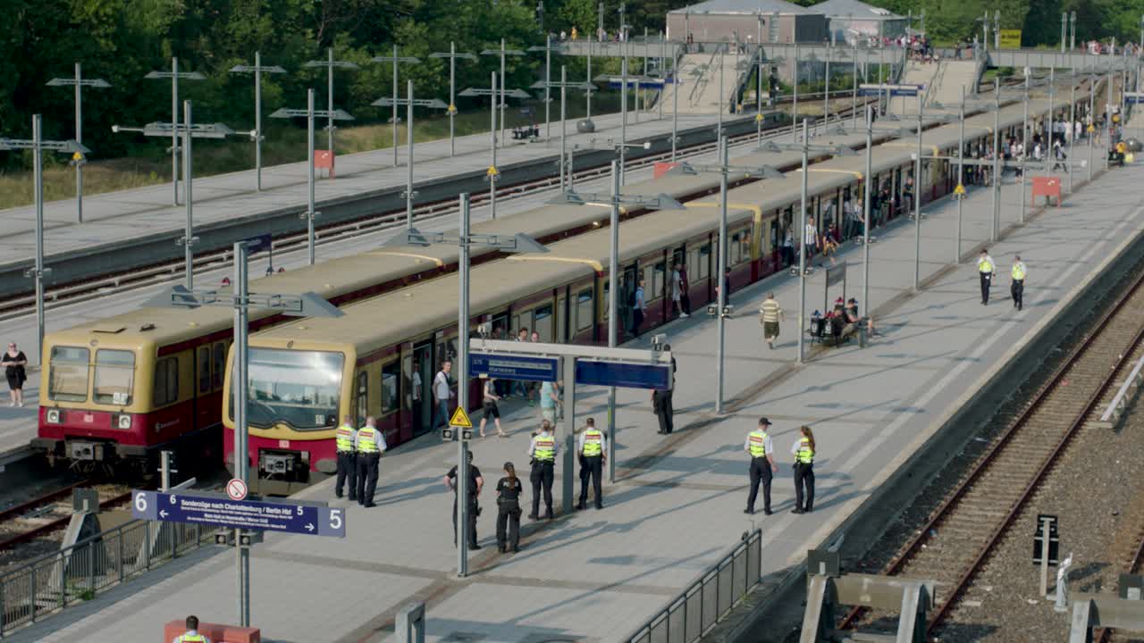 Outdoor Train Station With Crowded Platforms, Trains On Tracks, Signage ...