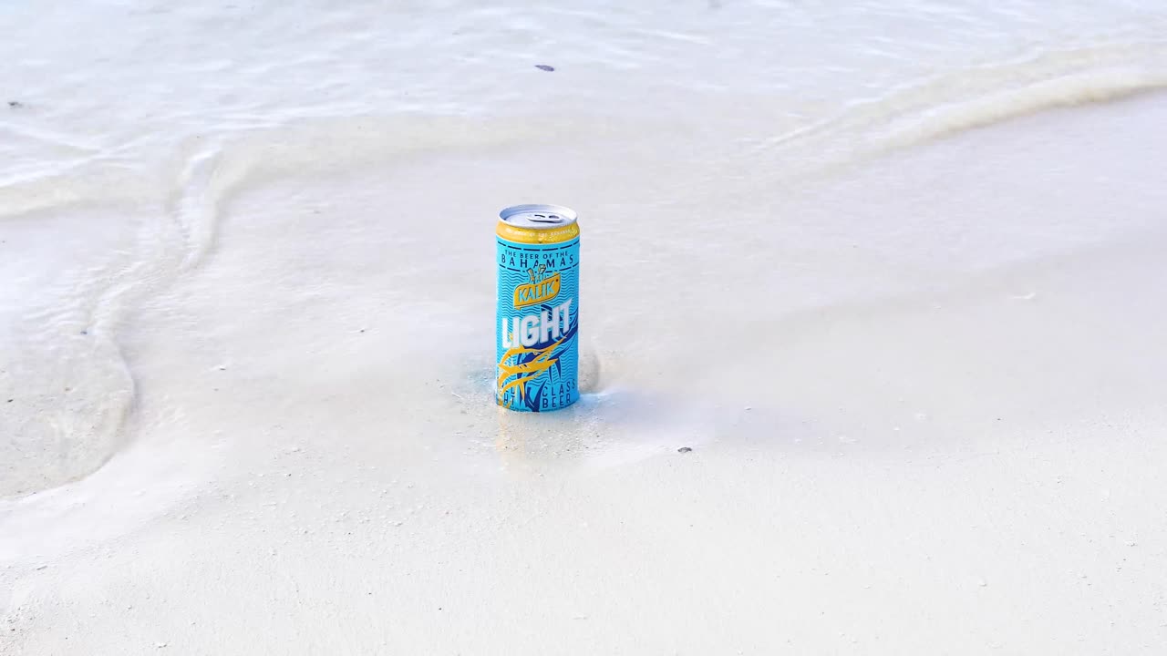This Is A Video Of A Can Of Kalik Light Beer On The Shoreline Of A ...