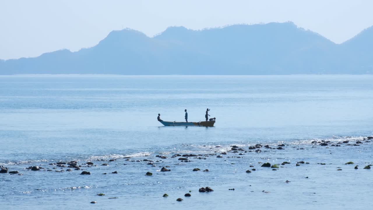 Group Of Local Timorese Fishermen In Small Wooden Boat Bringing In ...