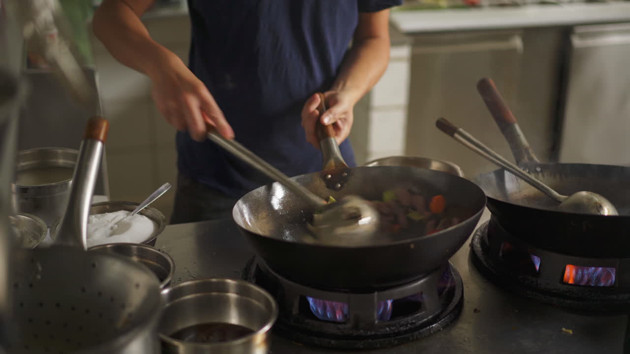Close Up Front Angle Shot Of A Chef Frying The Veggies And Swings A Wok ...