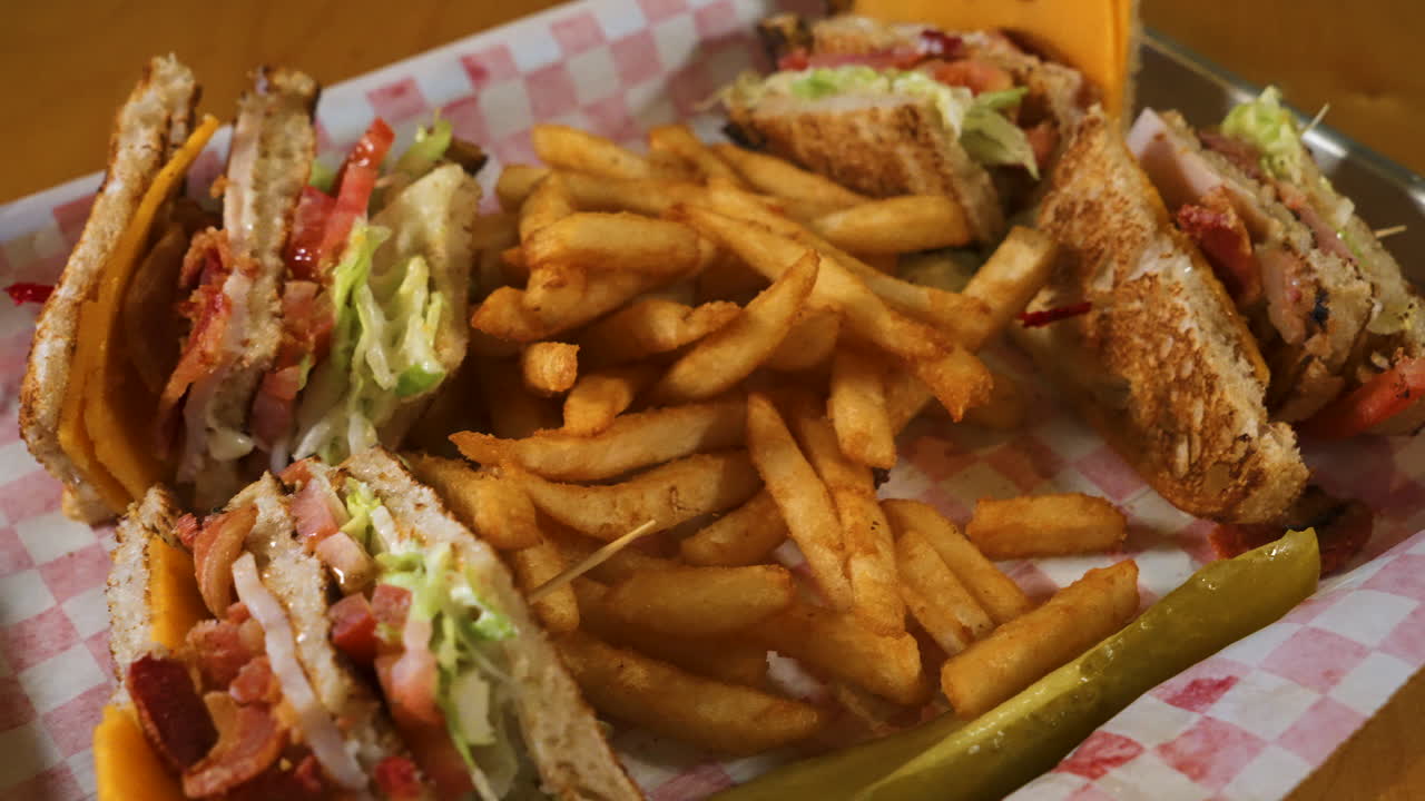 Premium stock video - Club sandwich cut into four squares with fries ...