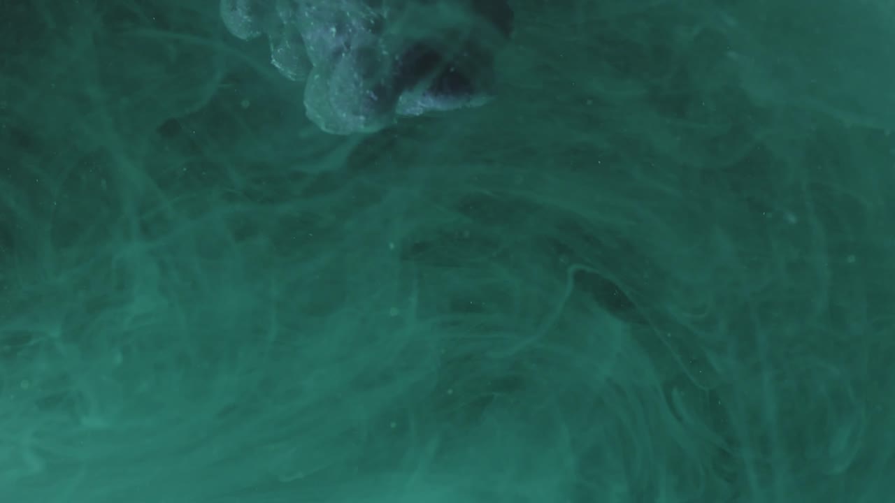 Premium stock video - Thick blue slime sinks in slow motion into a hazy ...