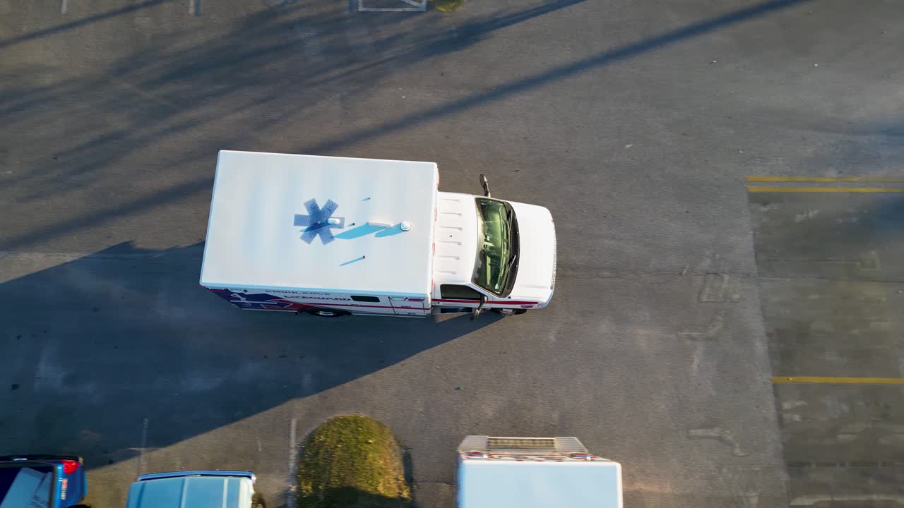 Premium stock video - Overhead view ambulance driving through parking lot