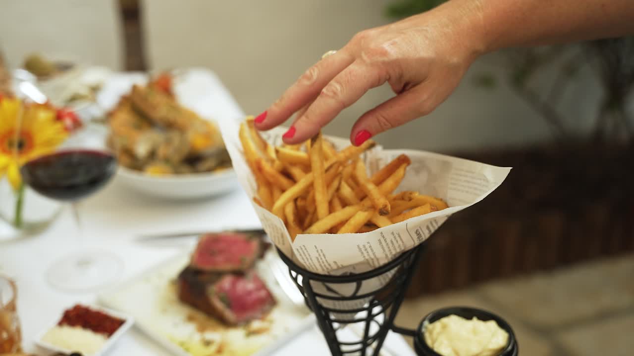Hand Grabbing A French Fry With Other Food On Table Slow Motion 4k 30p ...