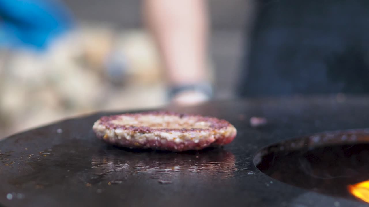 Premium stock video - Real chef grilling and flipping a burger patty on ...