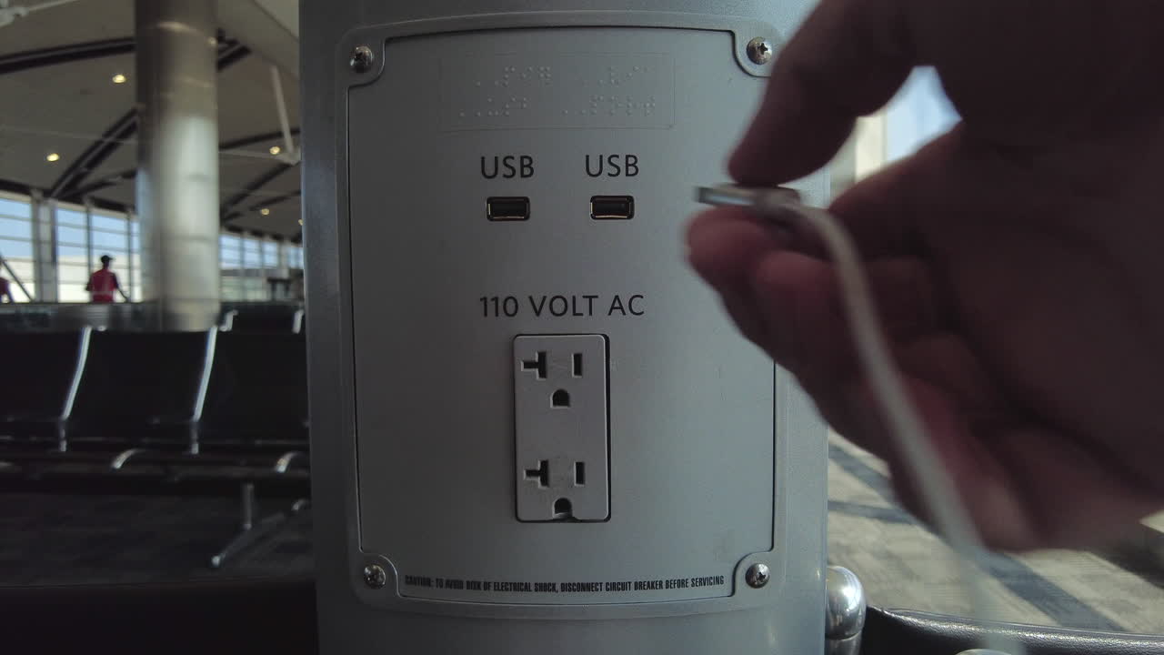 Unplugging A Cellphone Cable From A USB Charging Station At An Airport ...