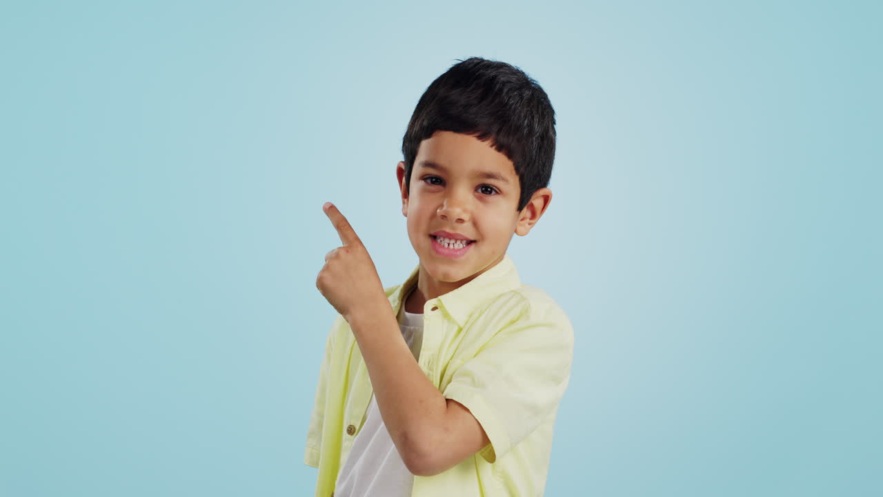 Boy, smile and pointing with excitement in studio Premium Stock Video ...