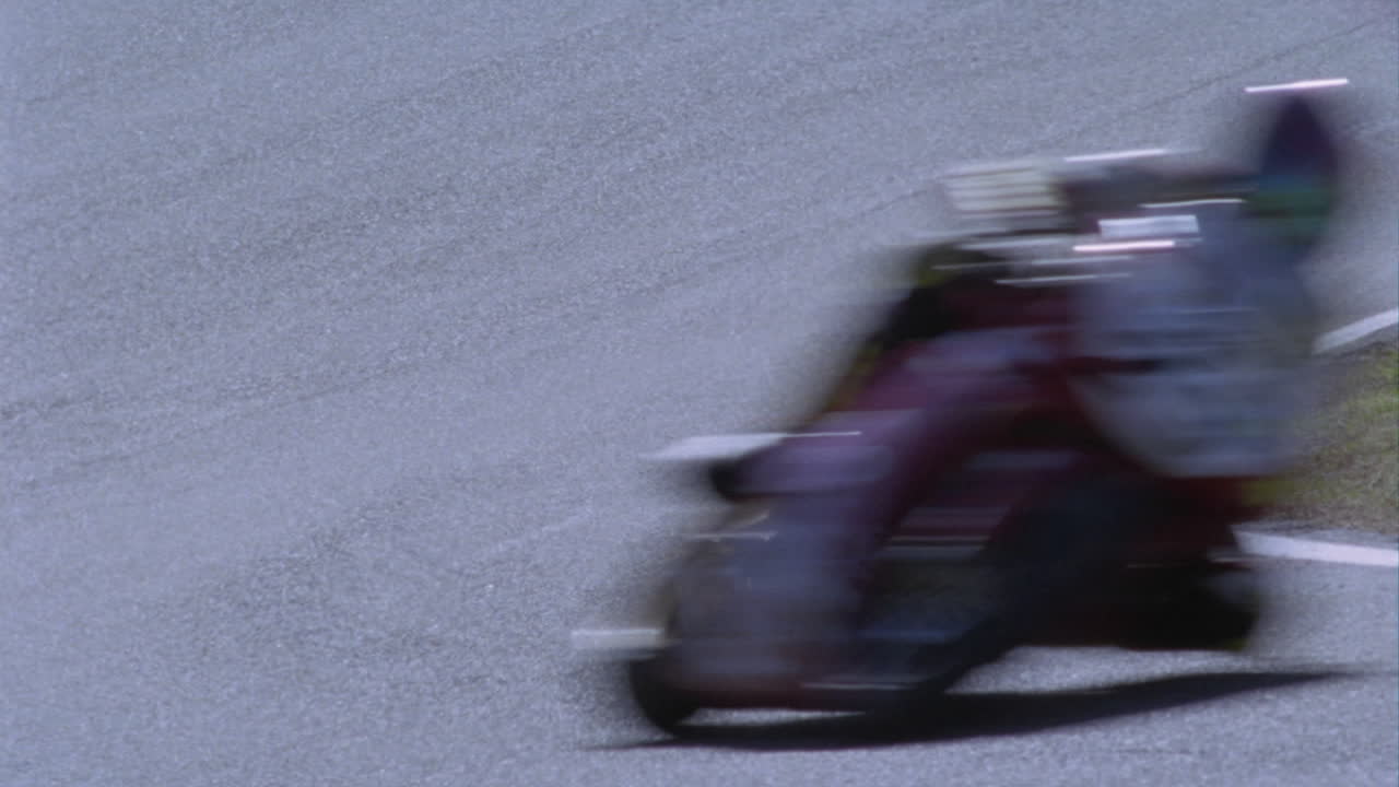 Premium stock video - A motorcycle rider heads into a sharp turn