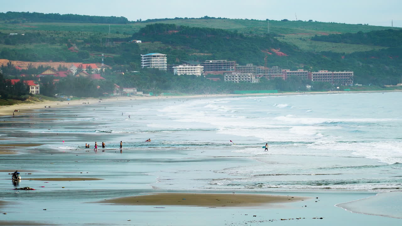 Premium stock video - Side view of ocean beach coast, resort on hill in ...