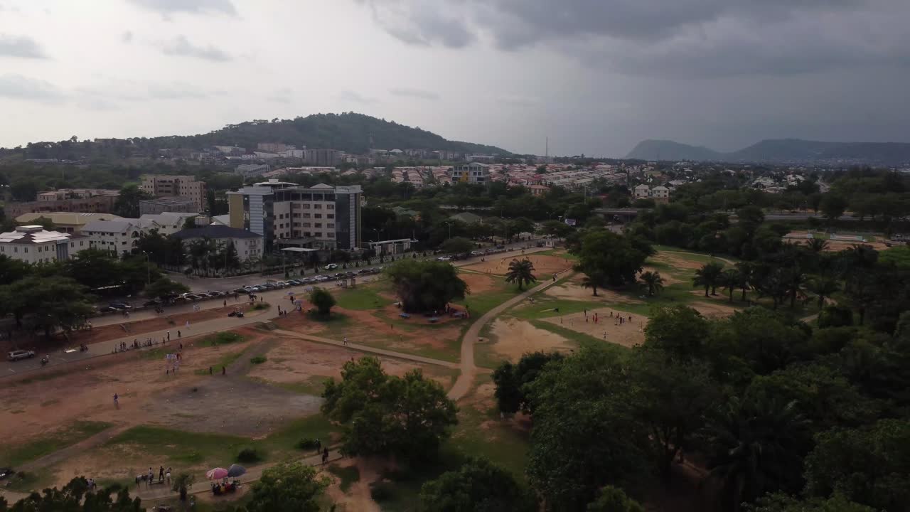 Aerial view of many people playing soccer on sandy field in Africa ...