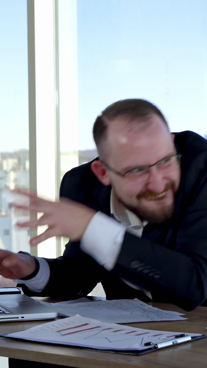 Businessman sitting at office desk. Angry worker looking at computer ...
