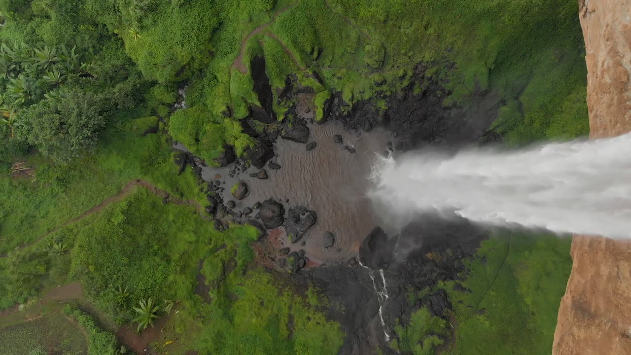 A moving forward aerial birds eye view shot of a waterfall in rural ...