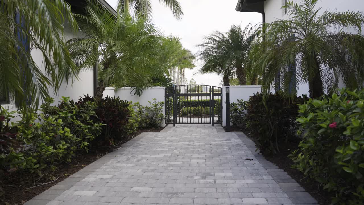 Premium stock video - Tropical walkway in a gated community with palm ...