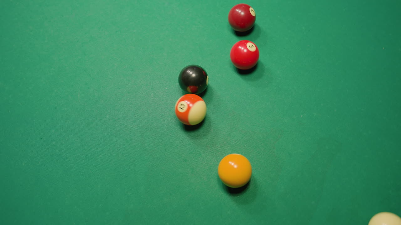 Vibrant billiard balls scattered across green pool table after powerful ...