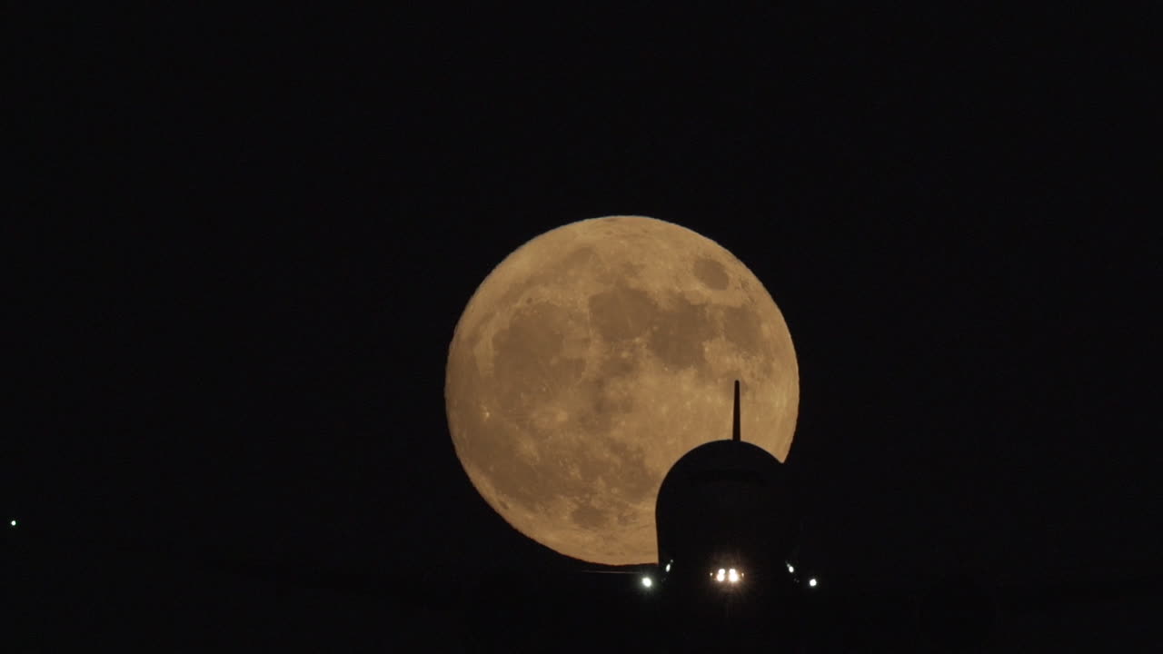 An Airliner Passes In Front Of A Full Moon On Approach To Landing At ...