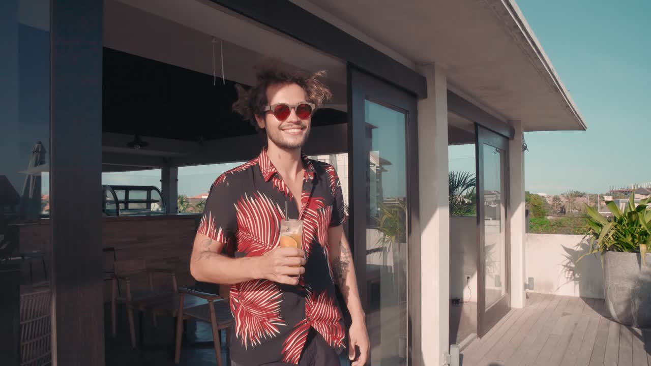 Free stock video - Young man goes out to the terrace holding a drink ...