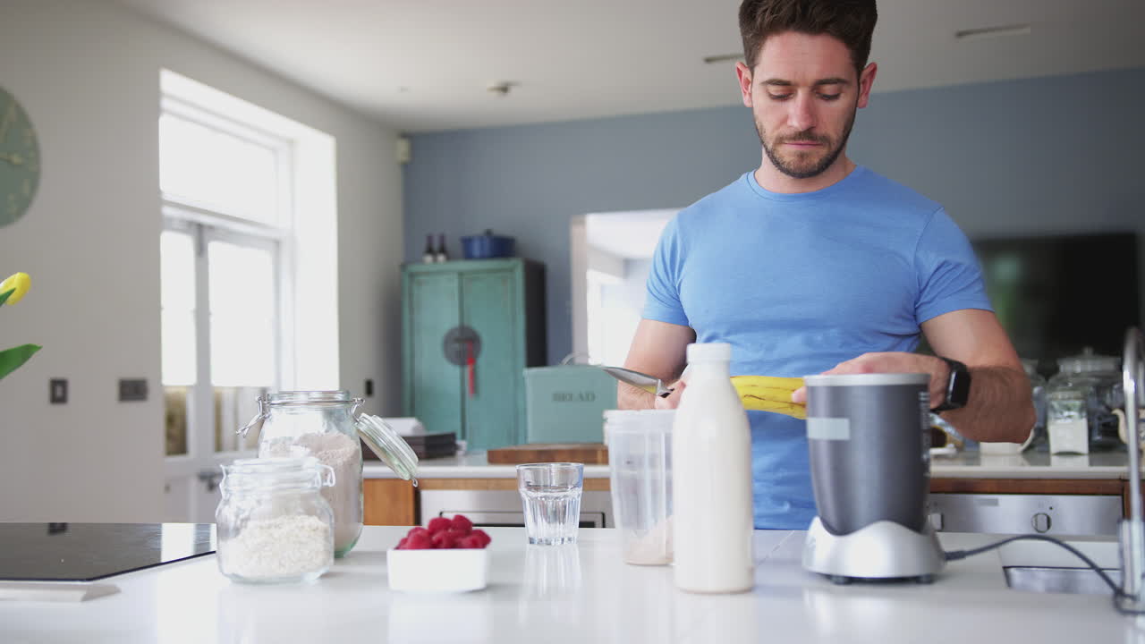 Premium stock video - Man making protein shake after exercise at home