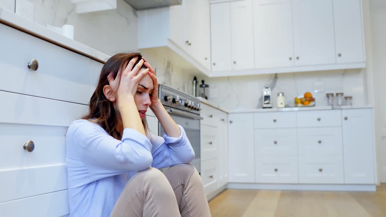 Premium stock video - Woman crying in kitchen at home 4k