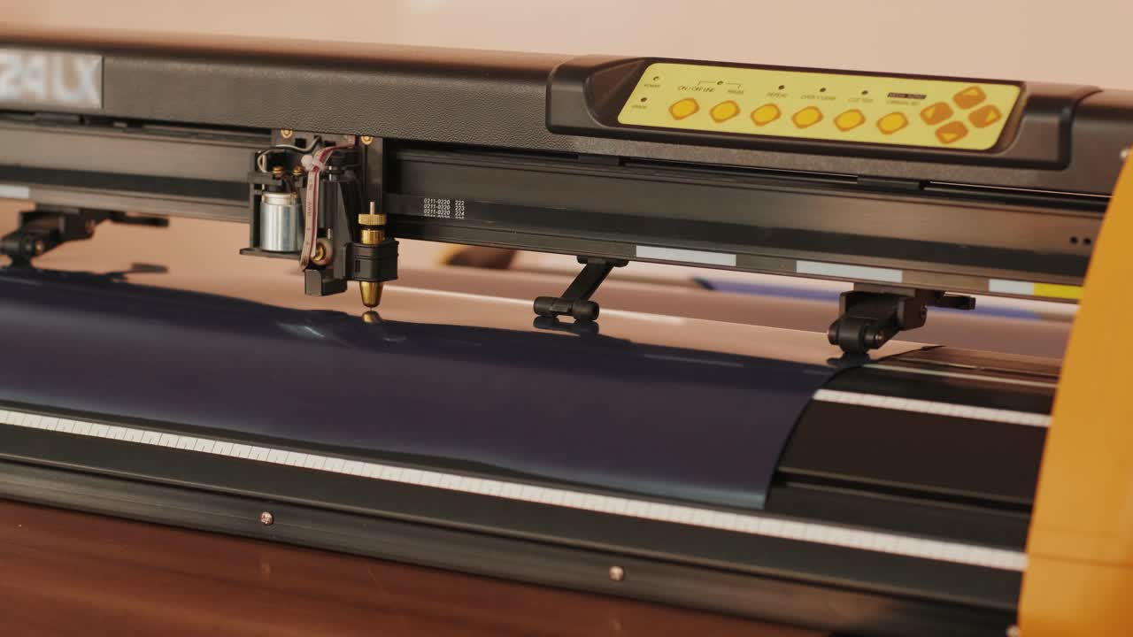 cnc machine cuts logo on tracing paper from plastic film. cutting ...