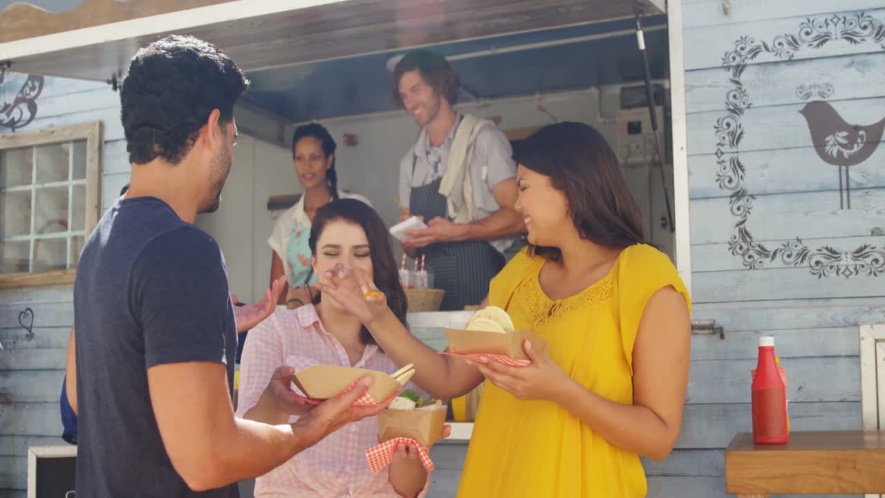 Premium stock video - Smiling friends eating snacks