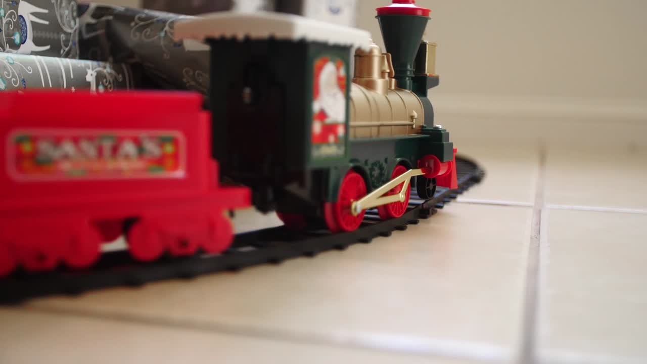Premium stock video - Toy train moving past christmas presents, slow motion