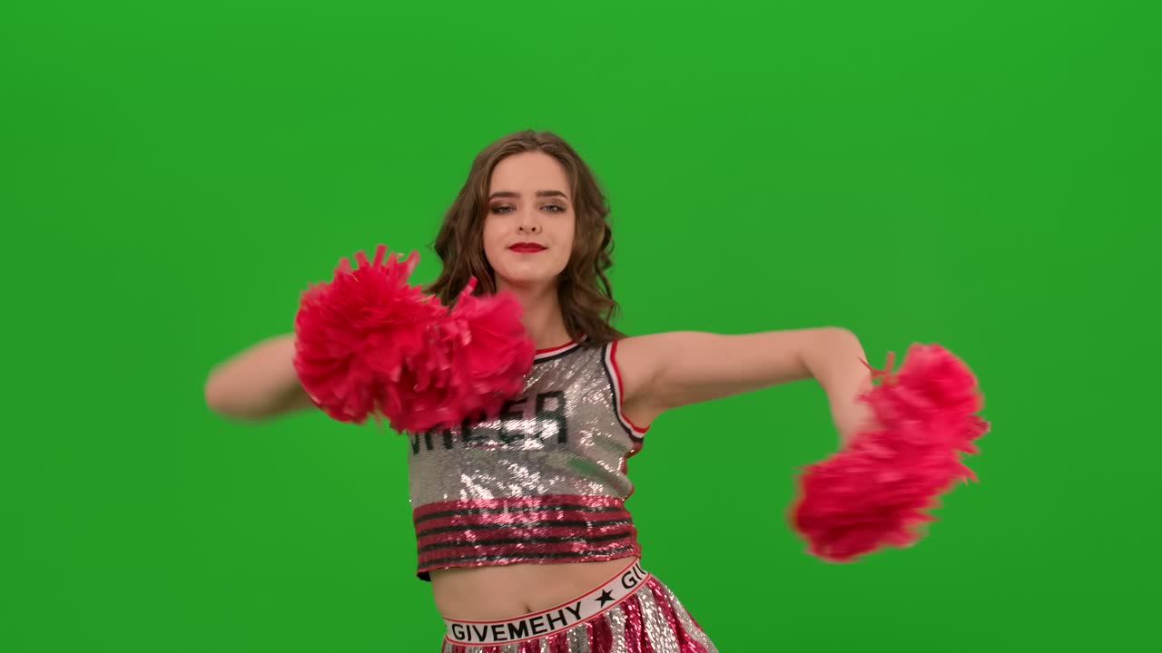 The cheerleader dances a jubilant pom-pom dance and moves her hips. The ...
