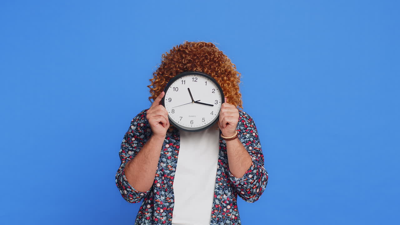 Serious strict stylish man holding office clock hiding behind checking ...