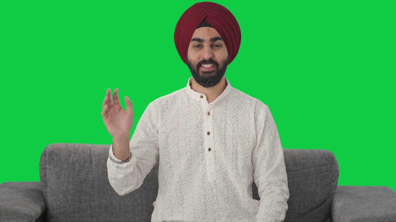 Premium stock video - Happy sikh indian man waving hello green screen