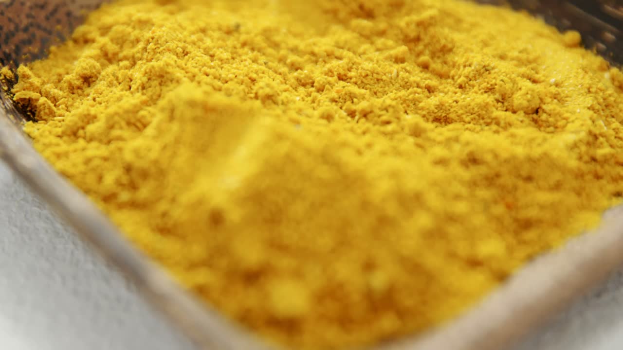 Turmeric powder in wooden bowl 4k | Premium Stock Video Footage