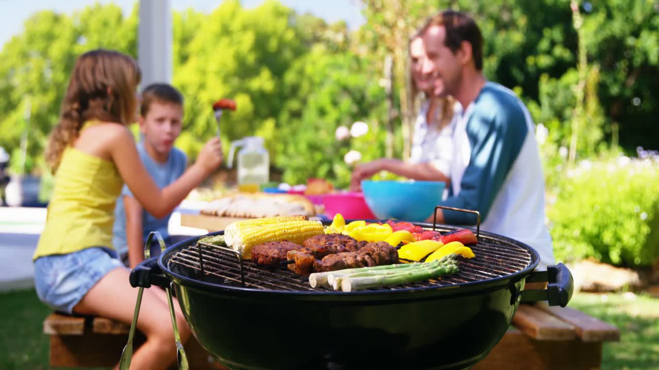 Premium stock video - Grilling meat and vegetables on barbecue