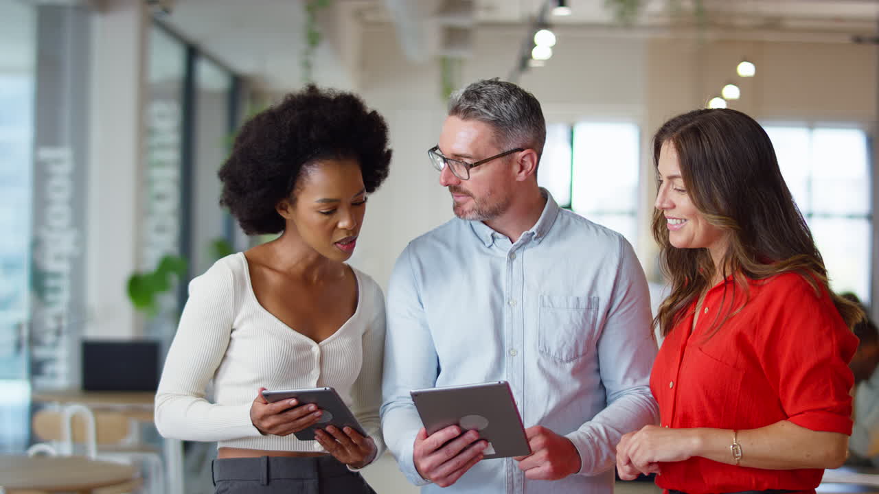 Premium stock video - Multi-cultural business team with digital tablets ...