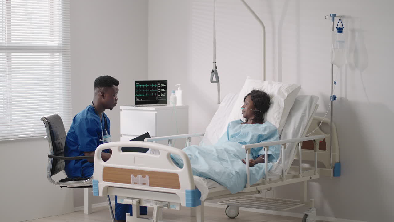 Premium stock video - An african male doctor interviews a patient lying ...