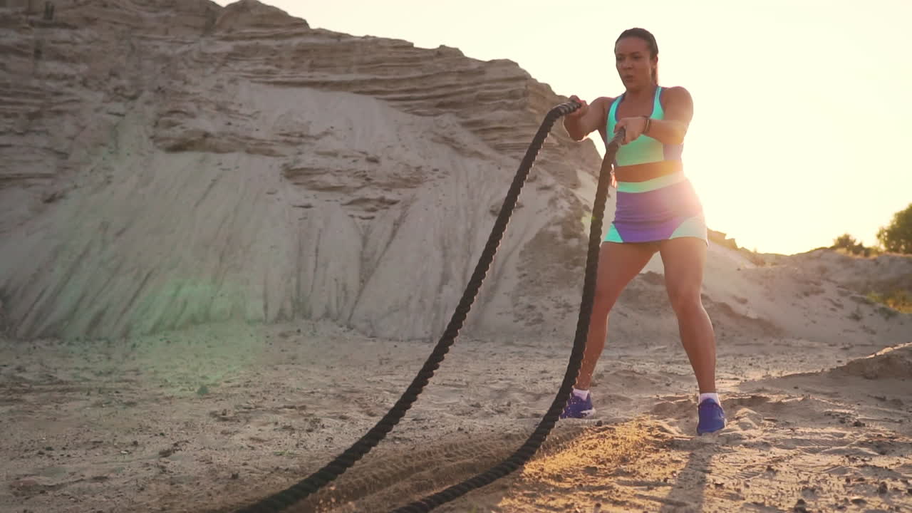 Female athlete training outdoors around the sand hills at sunset. active physical activity ...