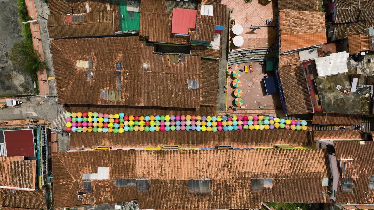 Aerial top down shot above a umbrella street in the Guatape Town, sunny ...