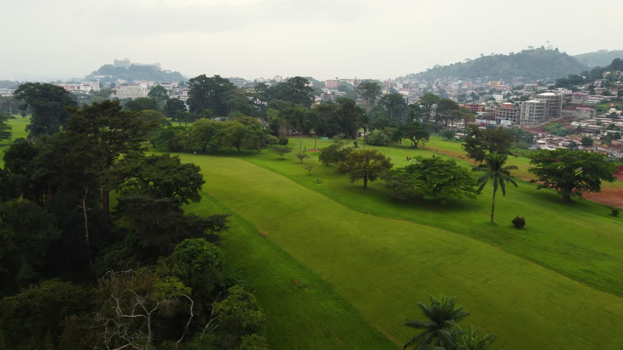 Aerial view flying over a golf course in yaounde city, cloudy day in ...