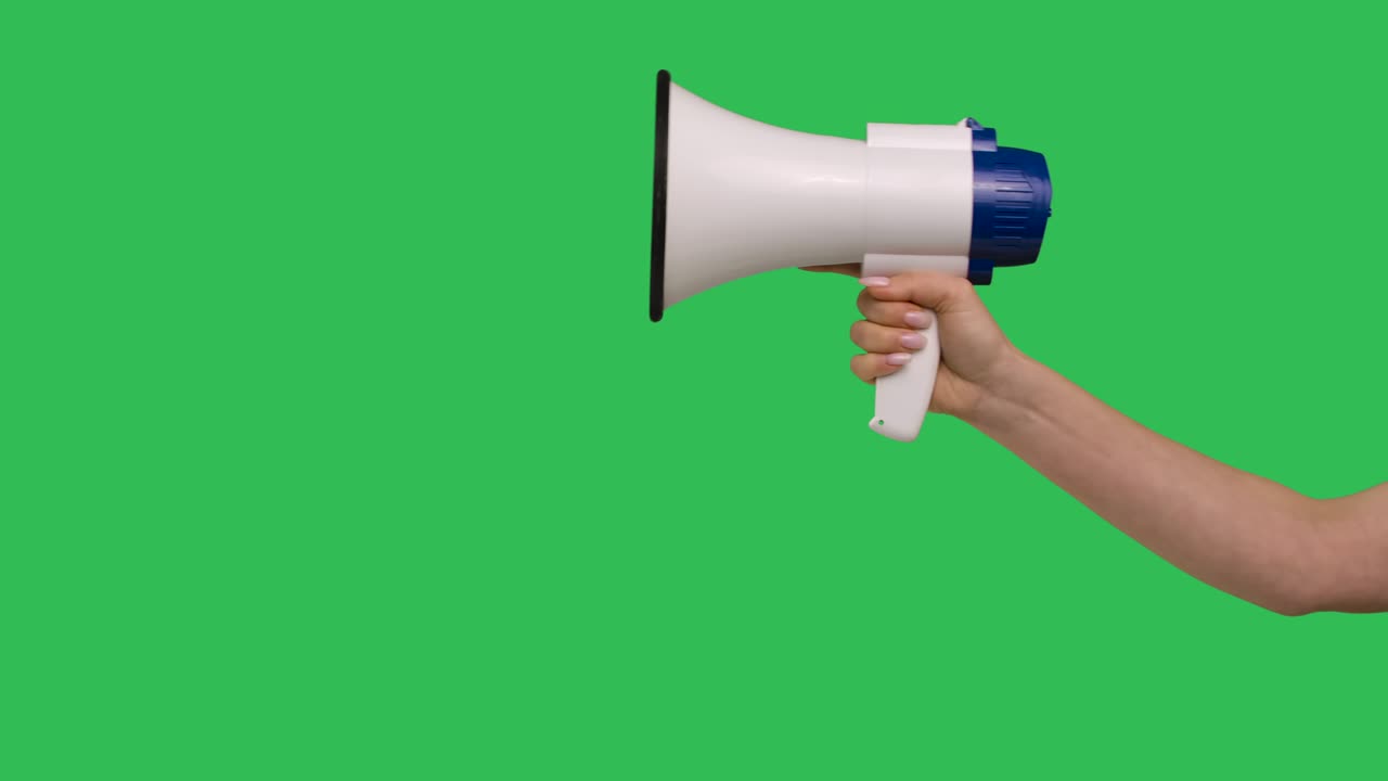 Megaphone close up rised in female hand on green screen chroma key ...